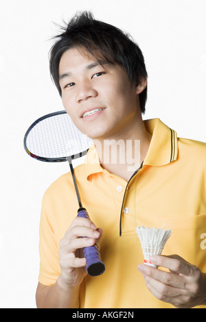 Asian man with badminton racket holding shuttlecock and ready in serve ...