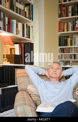 Senior man alone sitting at library looking at photo thinking close-up ...