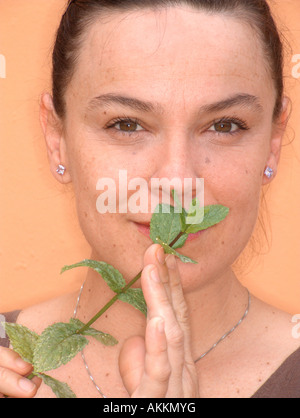 Woman smelling a branch of Mint (Mentha) plant Stock Photo - Alamy