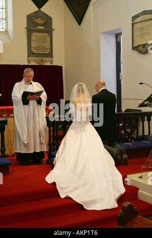 A bride and groom stand at the altar during their traditional church ...