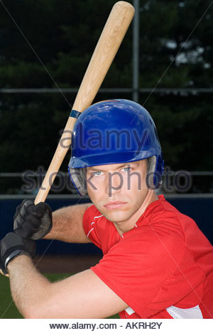 Baseball player holding bat, looking over shoulder Stock Photo ...