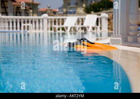 Flippers lying on the side of a swimming pool Stock Photo - Alamy