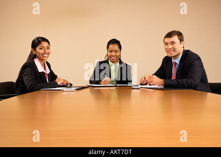 Businesspeople sitting at conference table smiling with flat screen ...