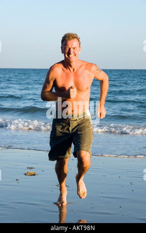 Colour portrait of 43 year old man walking along a beautiful beach ...