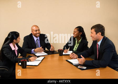 Businesspeople sitting at conference table smiling Stock Photo - Alamy