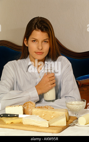 Woman holding board with different types of cut cheese and other snacks ...