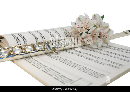 Silver flute lying on sheet music with lilies Stock Photo - Alamy
