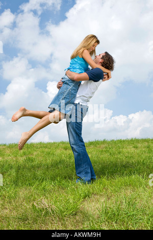 Man hugging woman lifting her off the ground Stock Photo - Alamy