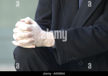 Folded hands resting on a lap Stock Photo: 4925845 - Alamy