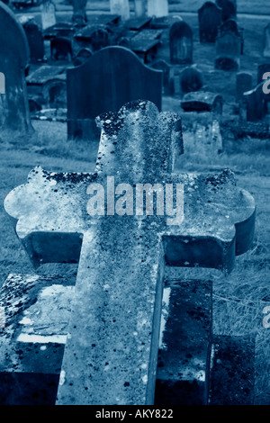 gravestone in atmospheric cemetery with blue cast Stock Photo - Alamy