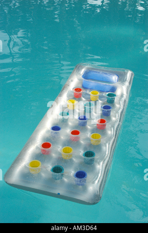 Bright yellow lilo floating in the sun on a rippling blue swimming pool ...