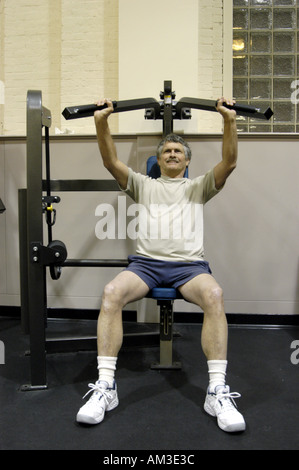 Older man exercising with shoulder press machine Stock Photo - Alamy