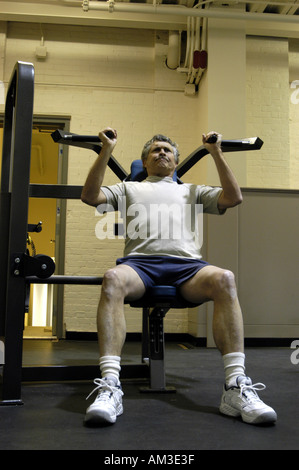 Older man exercising with shoulder press machine Stock Photo - Alamy
