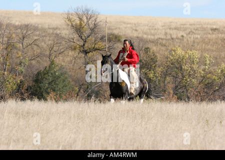 A Native American Lakota Indian riding horseback in the prairie of ...