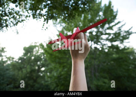 Hand holding a red toy plane on a on wooden texture Stock Photo - Alamy