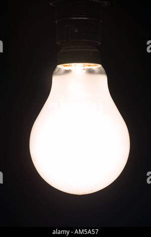 Shining lightbulb against black background Stock Photo - Alamy