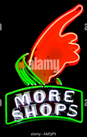Neon sign More shops with a hand pointing to the left and upwards ...