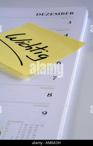 Yellow reminder note "Wichtig" (important) on the page of a calendar ...