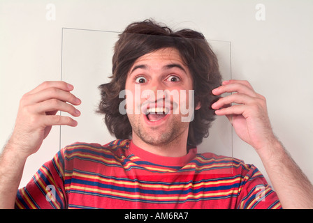 Man with face pressed up against window, studio shot Stock Photo - Alamy
