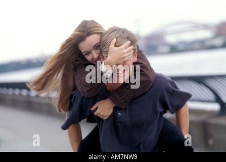 Portrait of a joyful young man and woman in white t-shirts sharing a ...