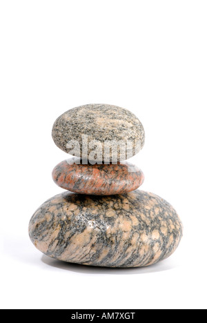 A vertical shot of a pile of a balanced stone pyramid with a wavy sea ...