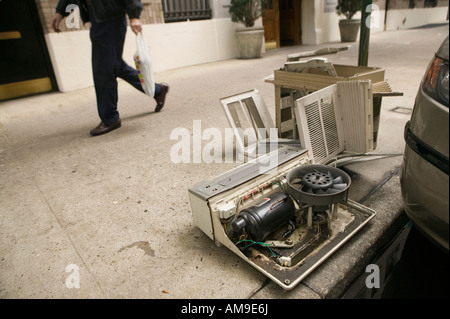 Parts of a broken air conditioner unit lie on a sidewalk in Manhattan ...