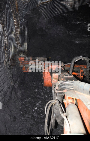 Jumbo mining equipment at stope face placing rock bolts and mesh for ...