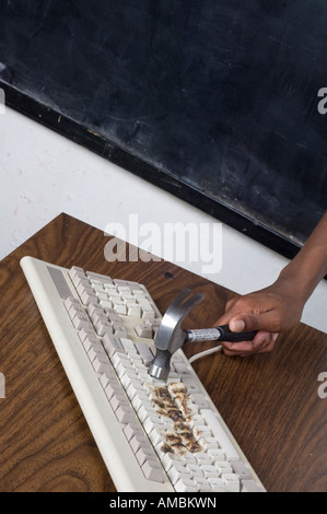 young boy breaking computer keyboard with a hammer Stock Photo - Alamy