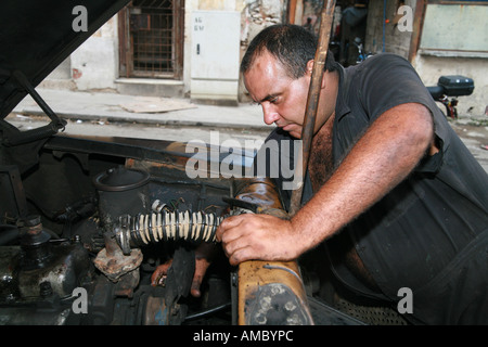 Cuban car mechanic repairing 1950s vintage American Chrysler pickup ...