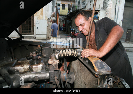 Cuban car mechanic repairing 1950s vintage American Chrysler pickup ...