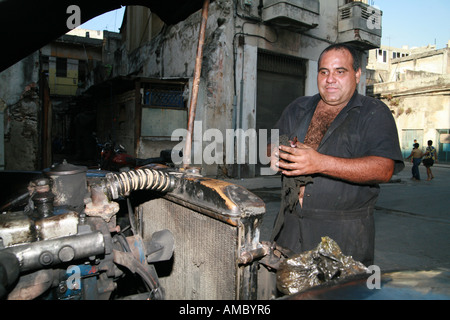 Cuban car mechanic repairing 1950s vintage American Chrysler pickup ...