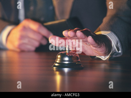 Man ringing hotel service bell on blurred background, closeup. Banner ...