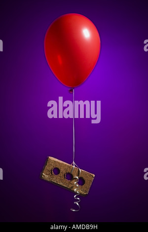 Helium balloon lifting brick Stock Photo - Alamy