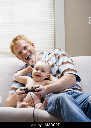 Baby on sofa with video game controller Stock Photo - Alamy