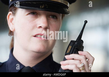 armed female police officer talking to mother carrying child at an ...