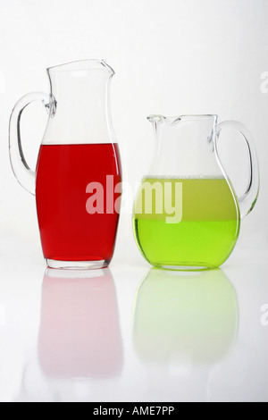 Two glass pitchers of Kool Aid Koolaid on white table background ...