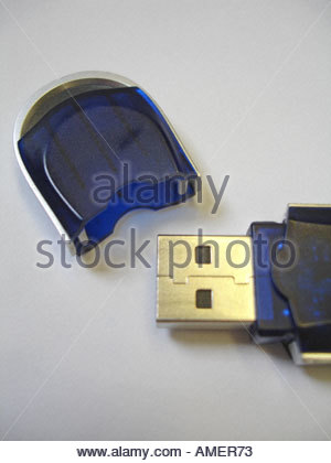 White usb flash stick with lid. On a pink background. Close-up, top ...