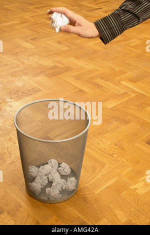 mans hand throwing scrunched up crunched ball of paper into a waste ...