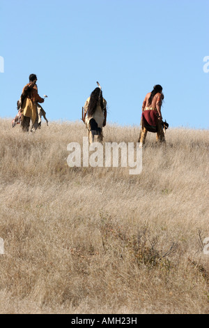 Three American Indians on the prairie with their paint colored horse ...