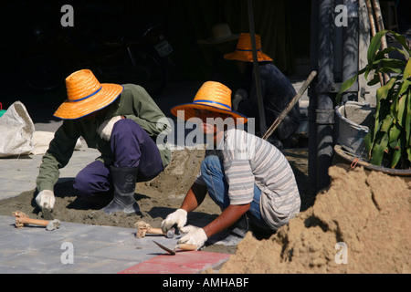 Shirtless workers repairing the pavement on the street under the ...
