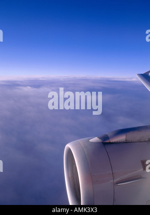 Close up of jet airplane soaring through the cloudy sky. Underside view ...