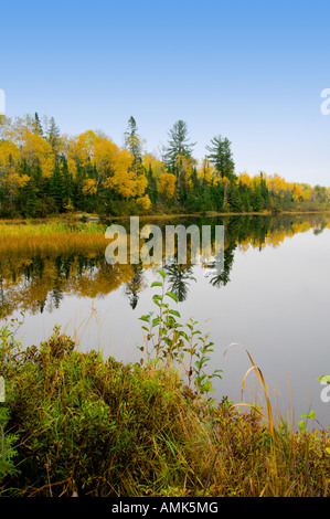 A calm lake with reflections and fall foliage color in rural Vermont ...