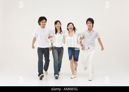 Cheerful young Asian man in glasses spending time with friends at home ...