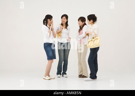 young Asian women talking on phone sitting on sofa in living room at ...