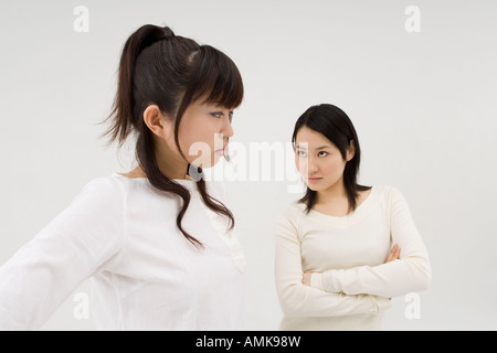Two young women glaring at each other Stock Photo - Alamy