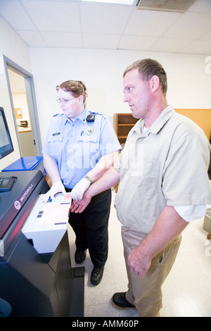 Inmate having his fingerprints digitially scanned as part of the intake ...