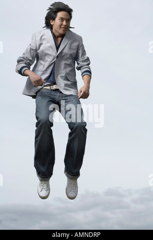 Happy young Chinese man jumping Stock Photo - Alamy