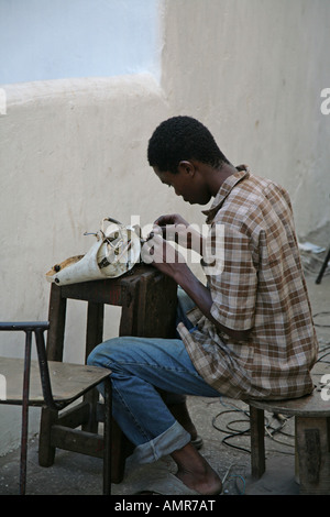 Young man repairing sewing machine Stock Photo - Alamy