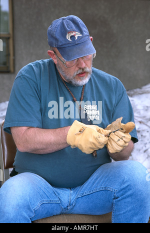 A flintknapping student is working on an arrowhead using the pressure ...