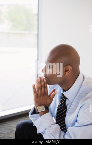 High angle view of bald african american senior man meditating in prayer pose on mat at log ...